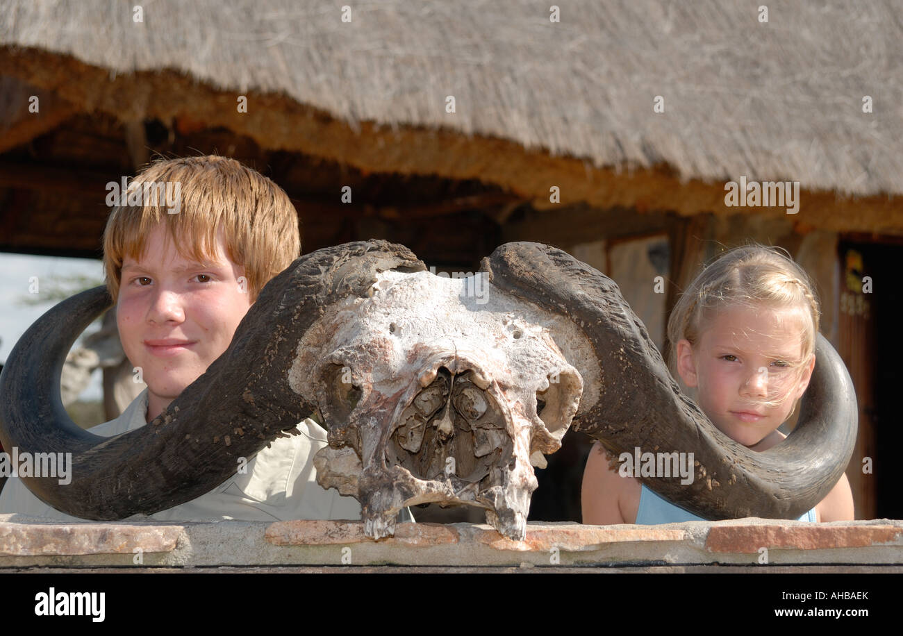 Two white children pose inside the curling horns of a buffalo skull in ...