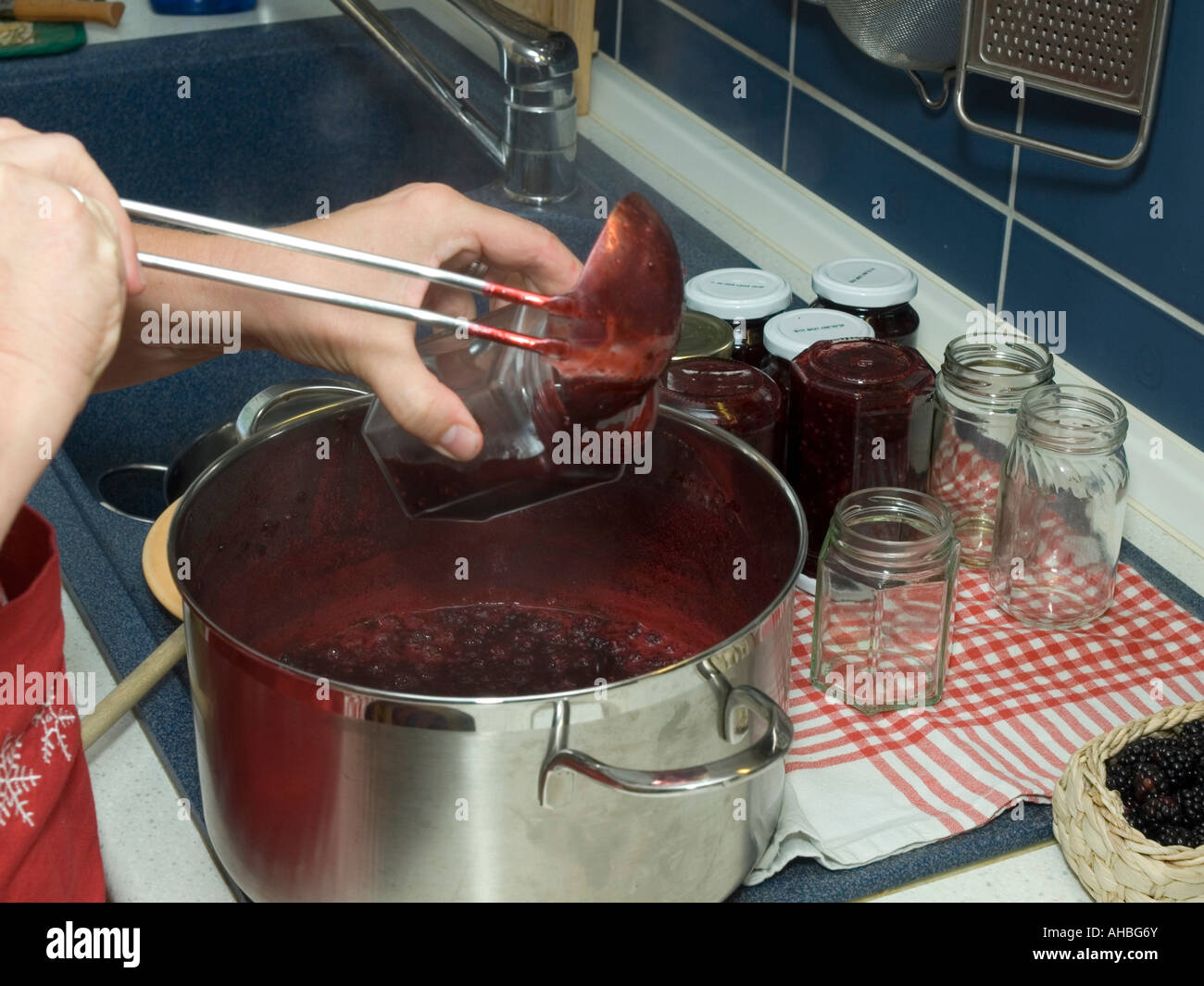 making jam from blueberries filling glasses from cooking pot MR Stock ...