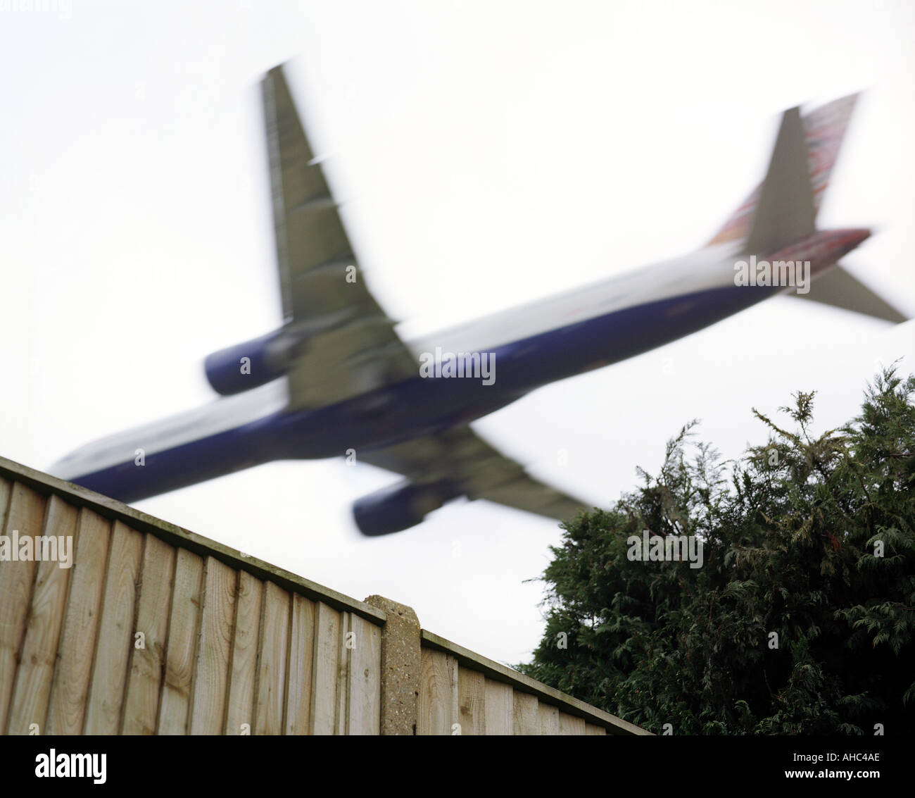 Plane over fence and hedge London UK Stock Photo - Alamy
