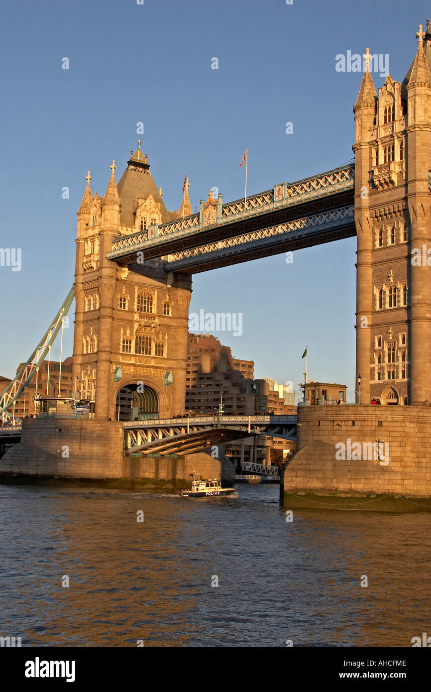 Police boat launch passing under Tower Bridge on River Thames in warm ...