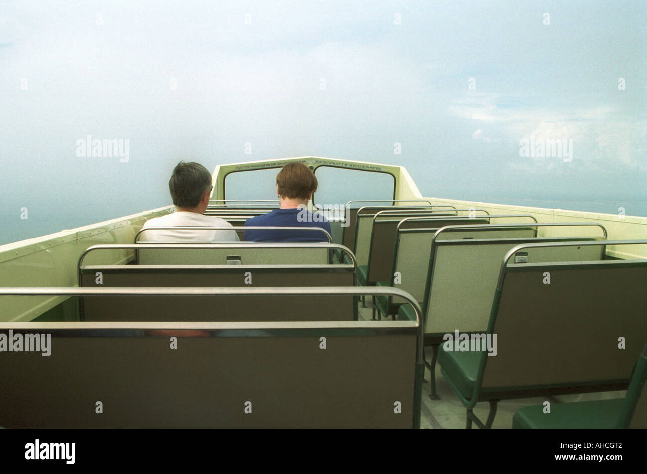 Two passengers on the top deck of an open top route master tourist bus ...