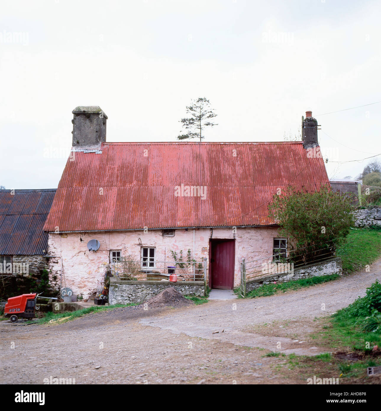 Traditional listed Welsh farmhouse with red corrugated iron roof ...
