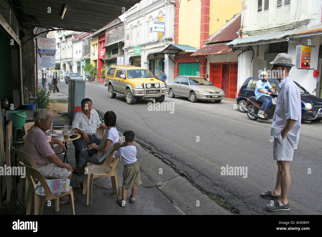 A western tourist watching people eating in a roadside restaurant in ...