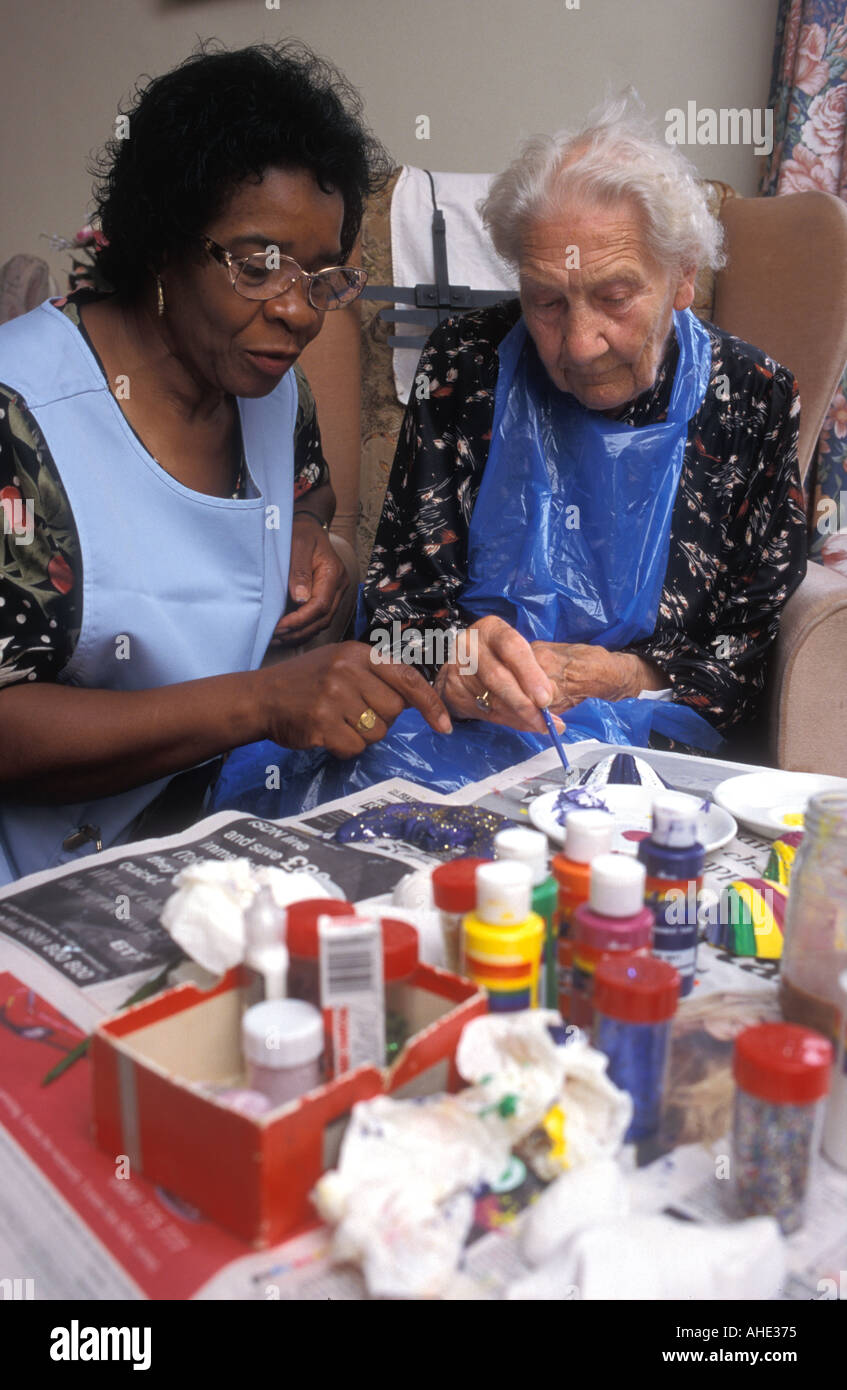 Elderly woman painting with care worker hi-res stock photography and ...