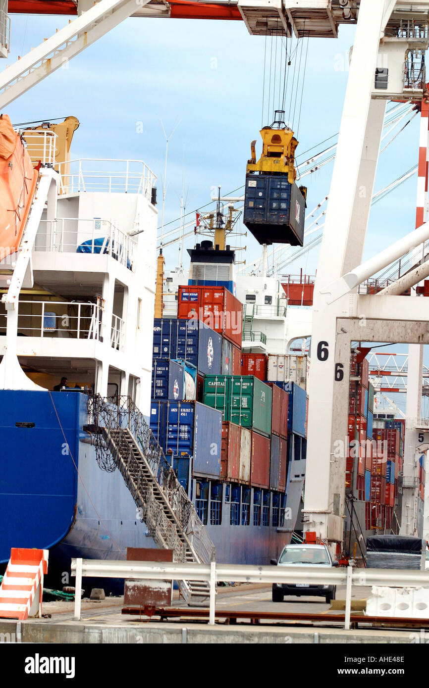 Crane charging container in cargo ship Stock Photo - Alamy