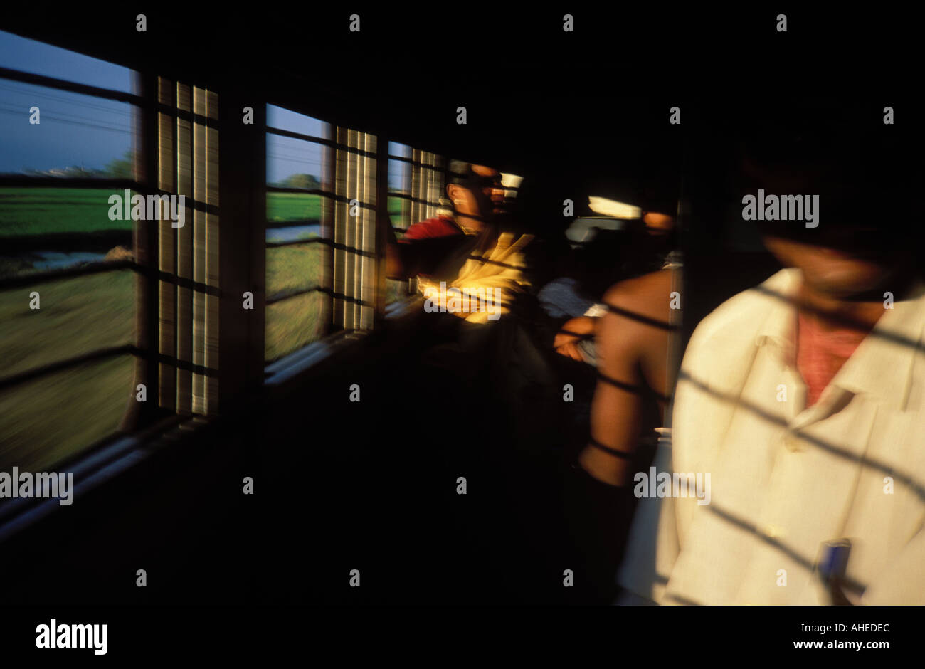 Evening sunshine streams through the window onto passengers on a train ...