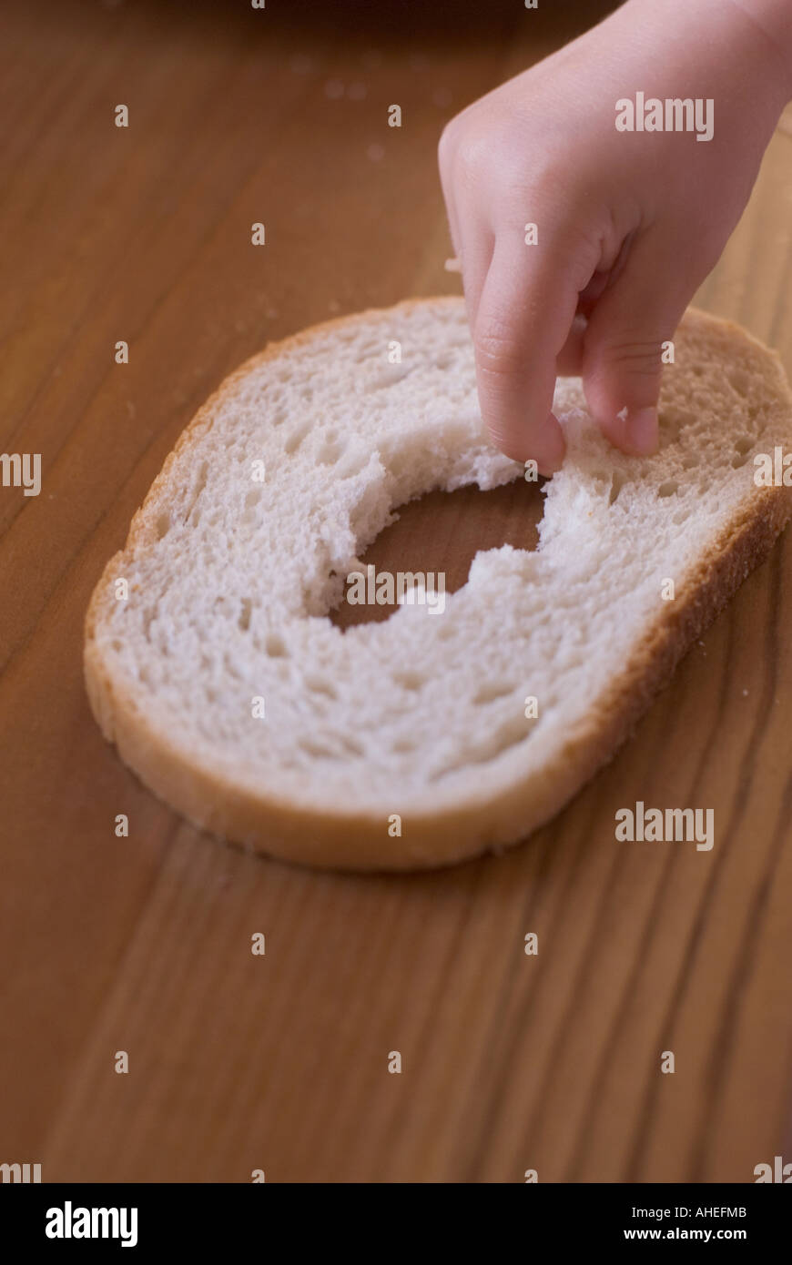 Little childs hand and slice of bread on table Stock Photo - Alamy