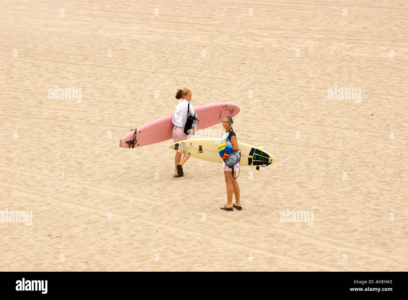 Two teenager girls walking towards the ocean carrying surf boards Stock ...