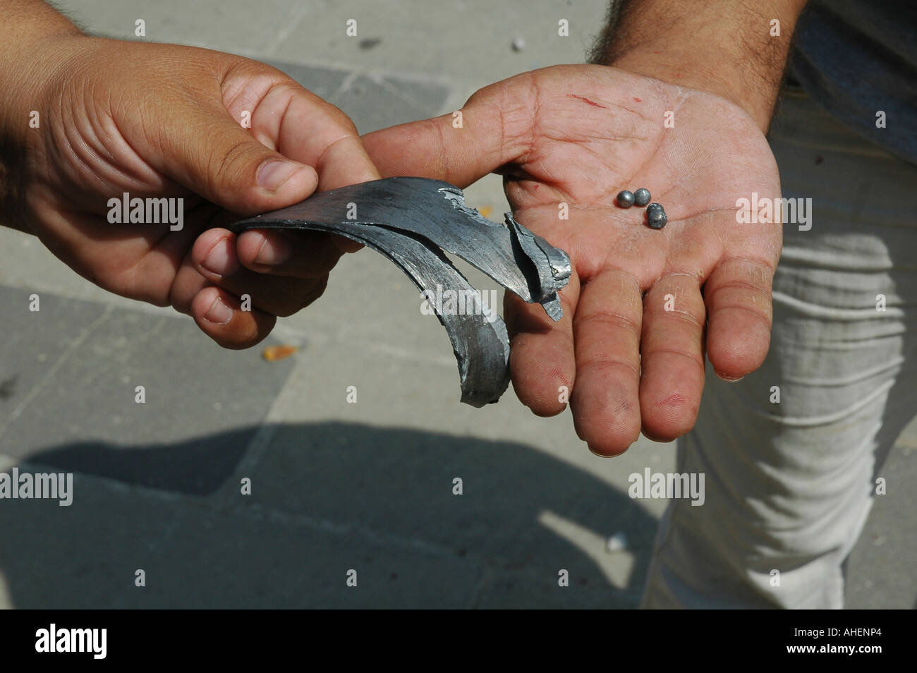 Israeli civilians hold shrapnel and ball bearings used to make a ...