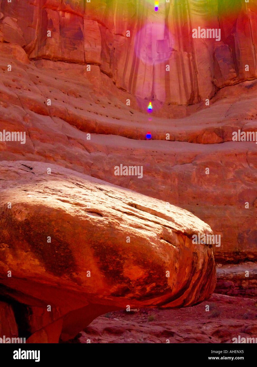Light striking a massive red rock formation in the summertime at Arches ...