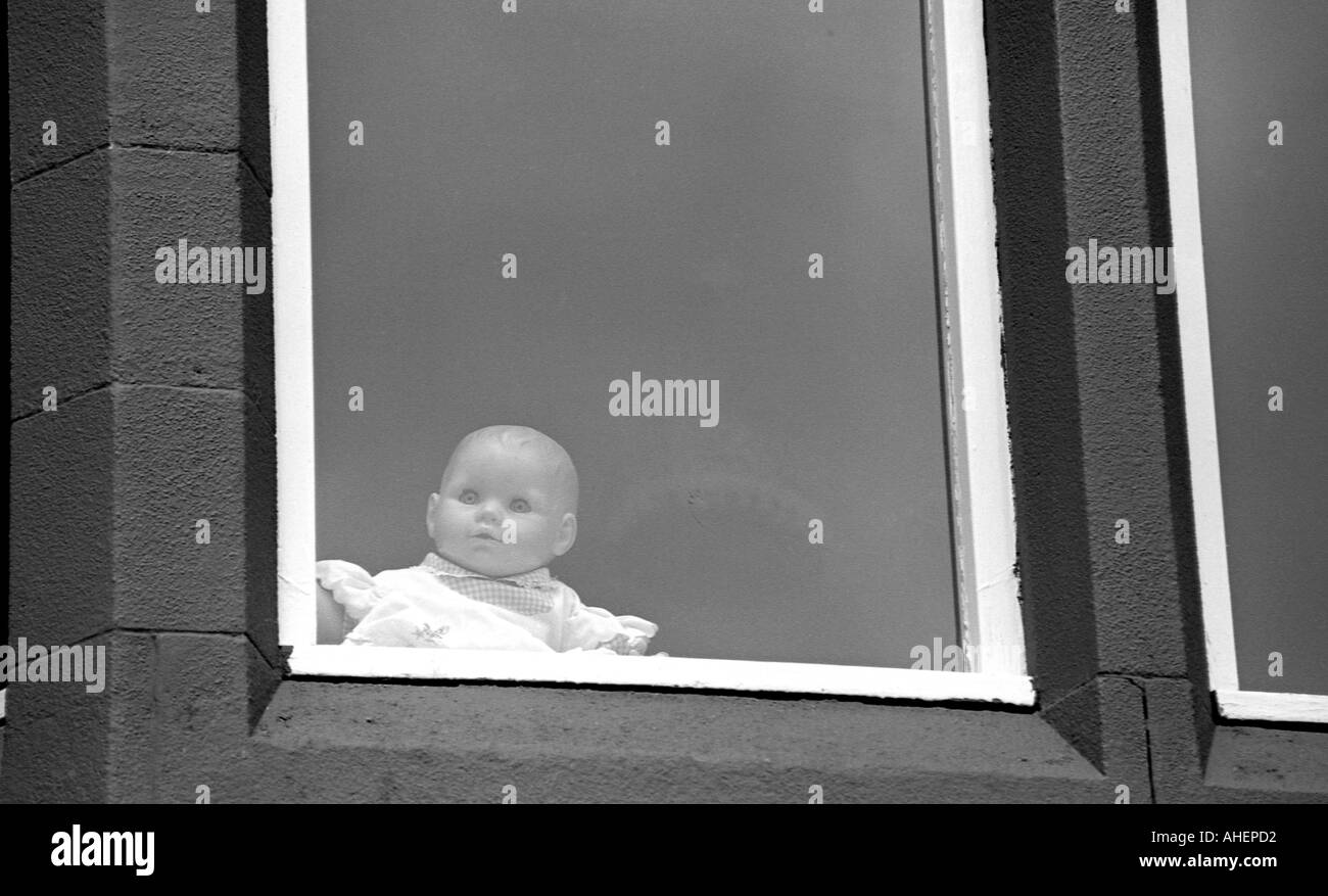Doll in bottom corner of house window looking very alone and lonely ...