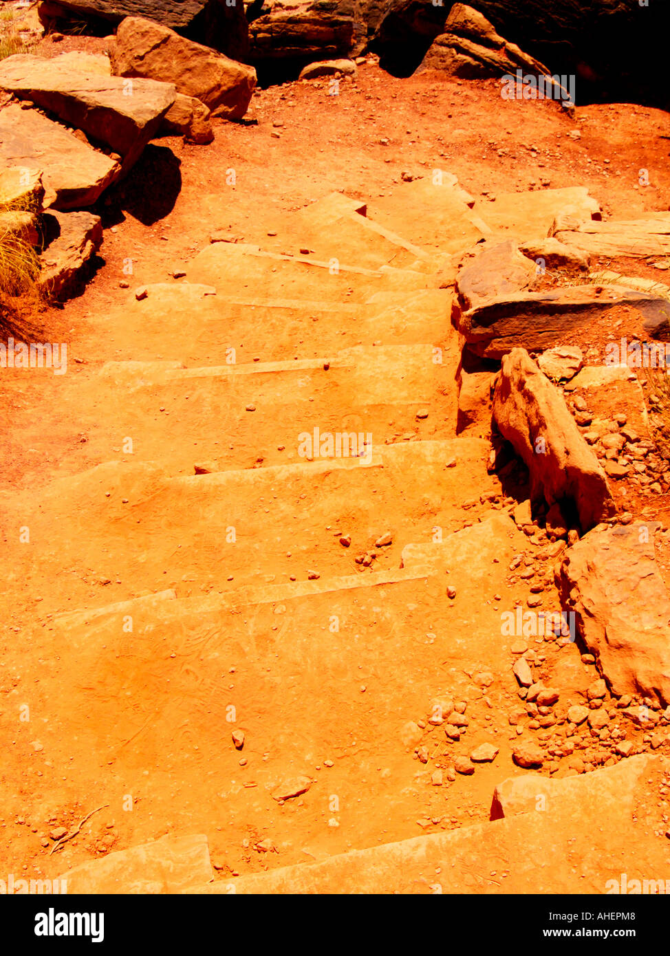 Stone stairway of intense red sandstone and red sand leading down into ...