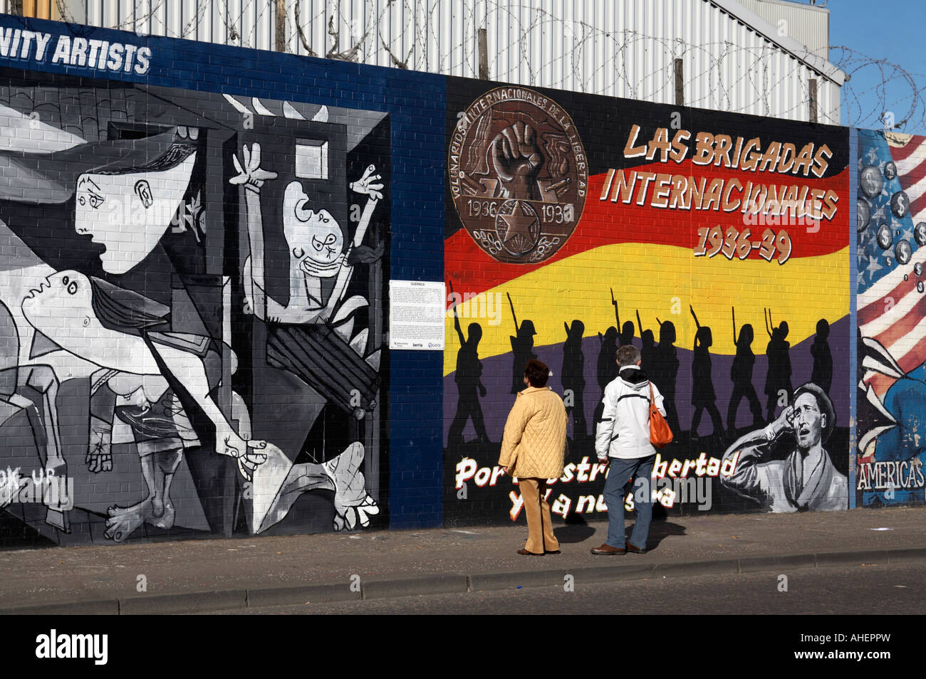 tourists browse International wall murals in the republican falls road ...