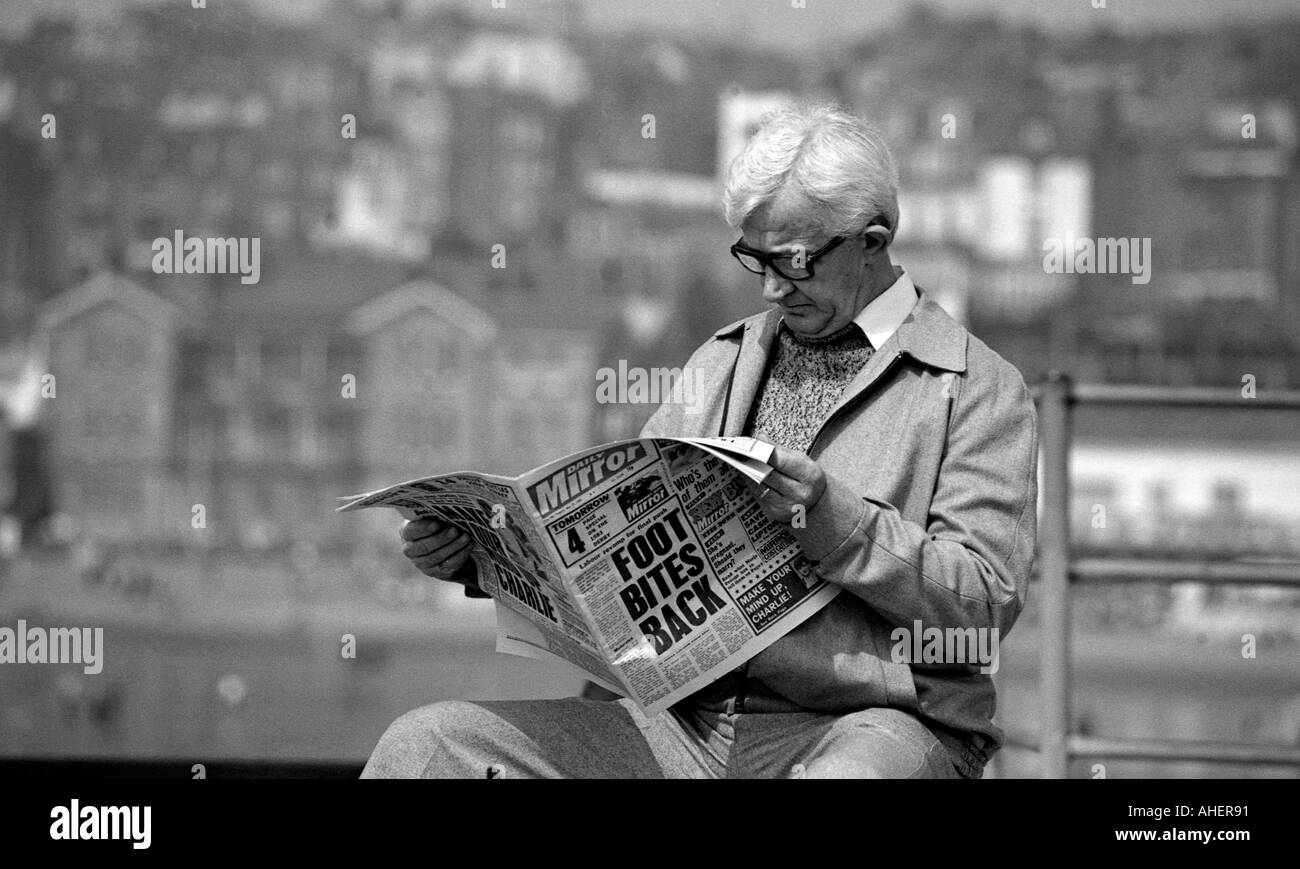 Man sitting reading daily newspaper at holiday resort Stock Photo - Alamy