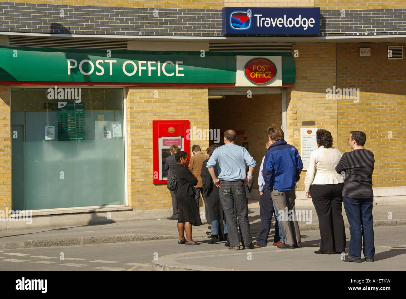 Lunch time queue of people waiting to withdraw their money from hole in ...