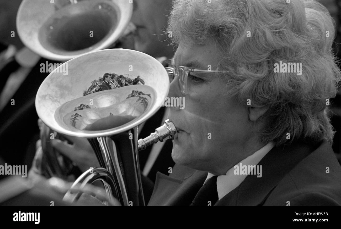 Woman playing a trumpet outdoors with other members of the band ...