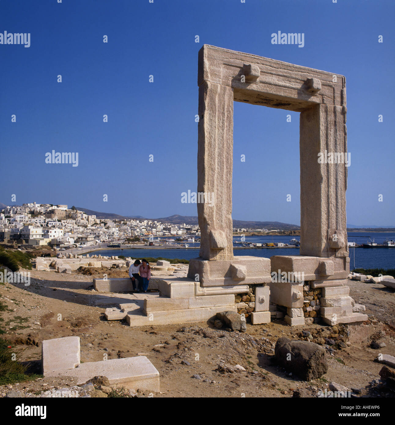 Square arched Temple of Apollo with couple at base and Naxos town and ...