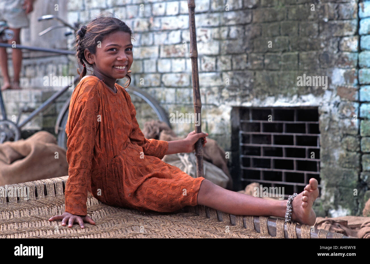 Indian girl seated on a traditional string bed Agra vegetable market ...