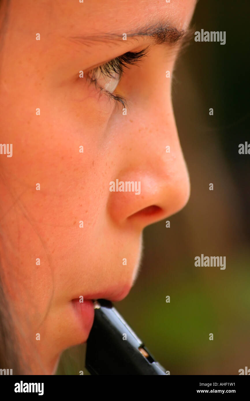 side profile of young girl playing penny whistle Stock Photo - Alamy