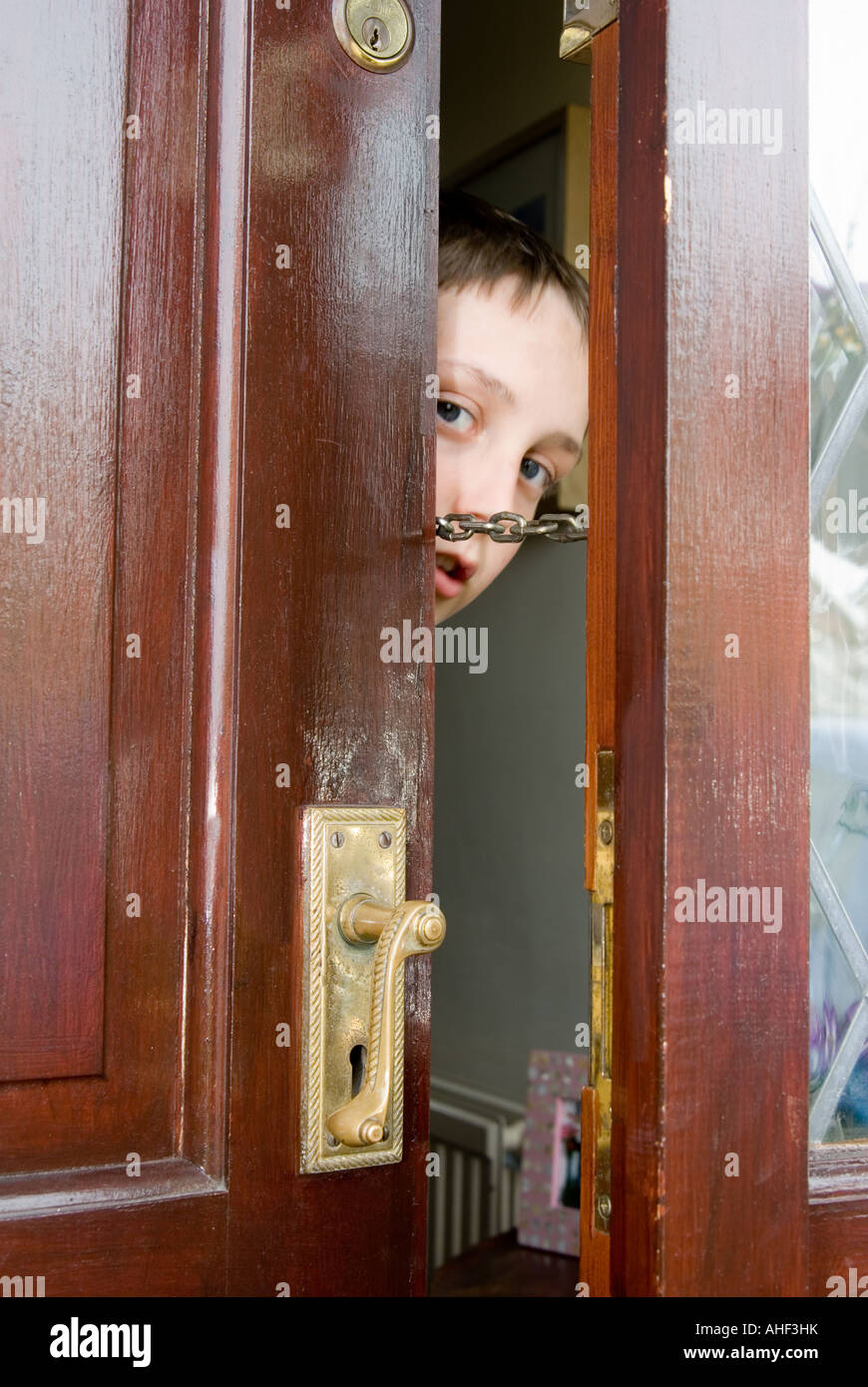 Child using a security chain on a front door Stock Photo - Alamy