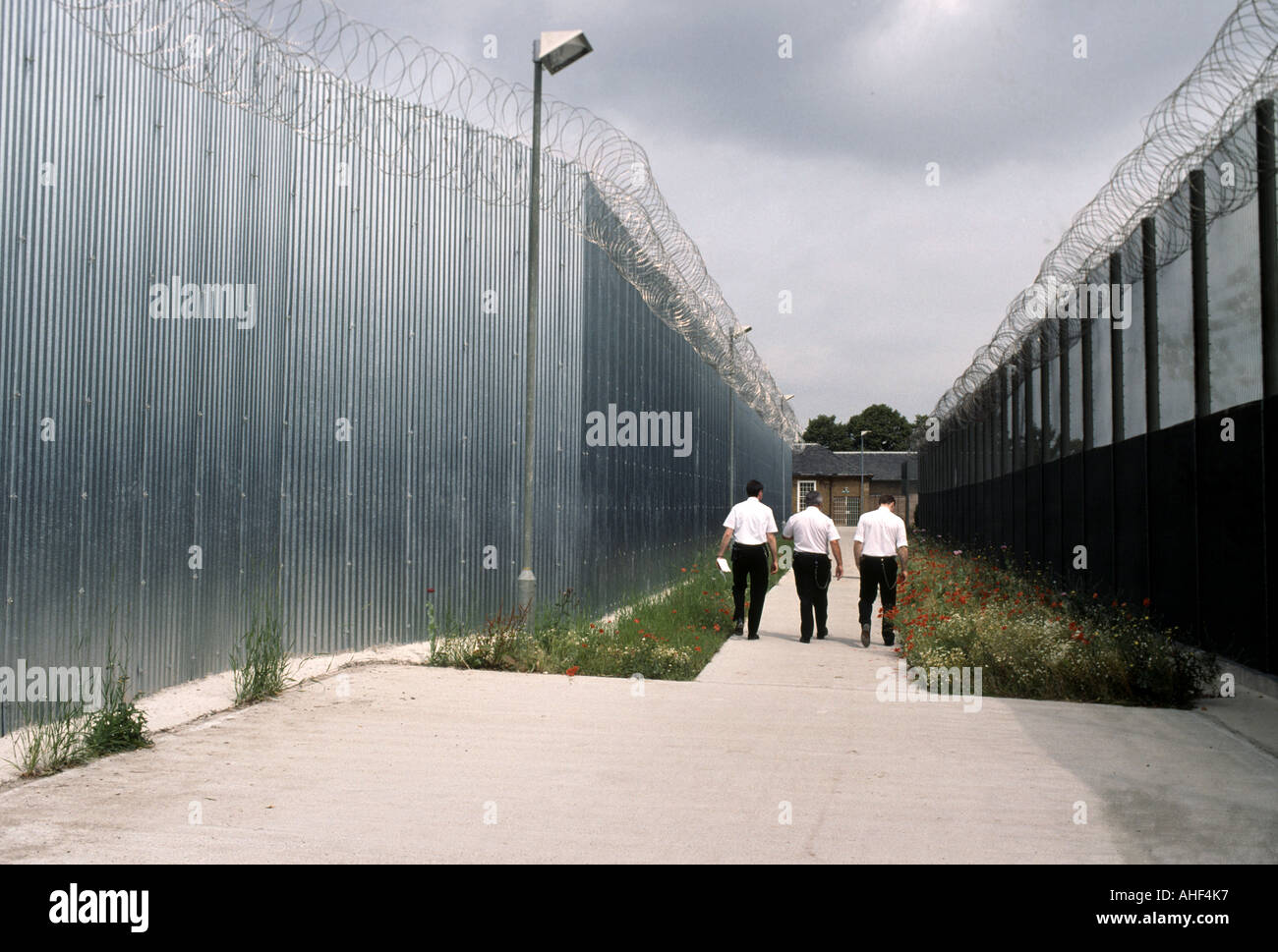 exterior of prison with guards walking through security walls Stock ...