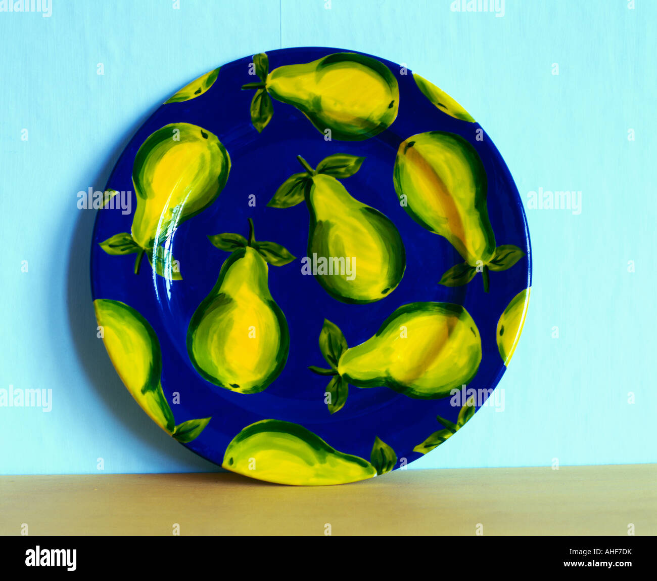 Blue pottery plate with yellow pear design Stock Photo - Alamy