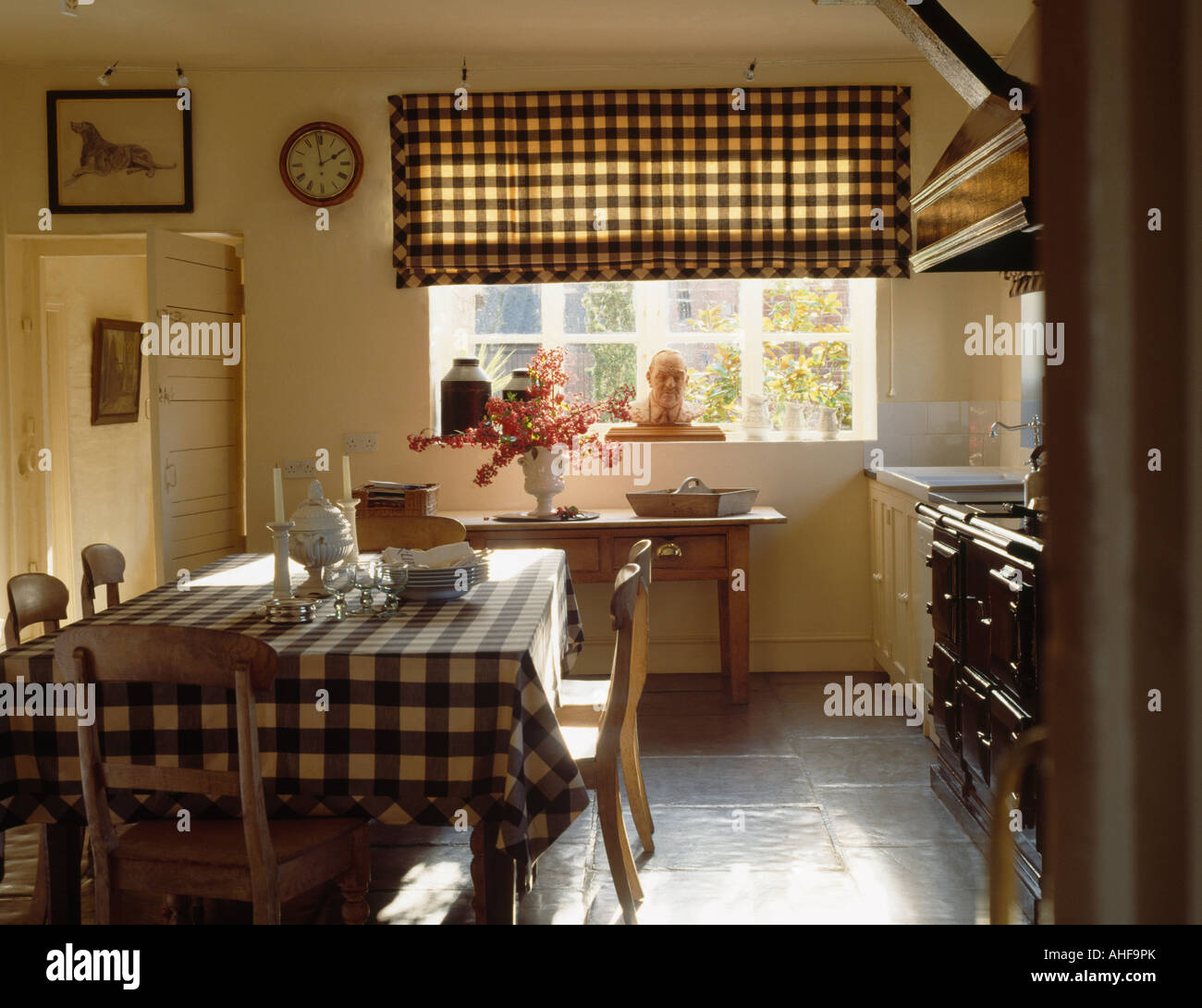 Checked blind and blue checked cloth on table in country kitchen with ...