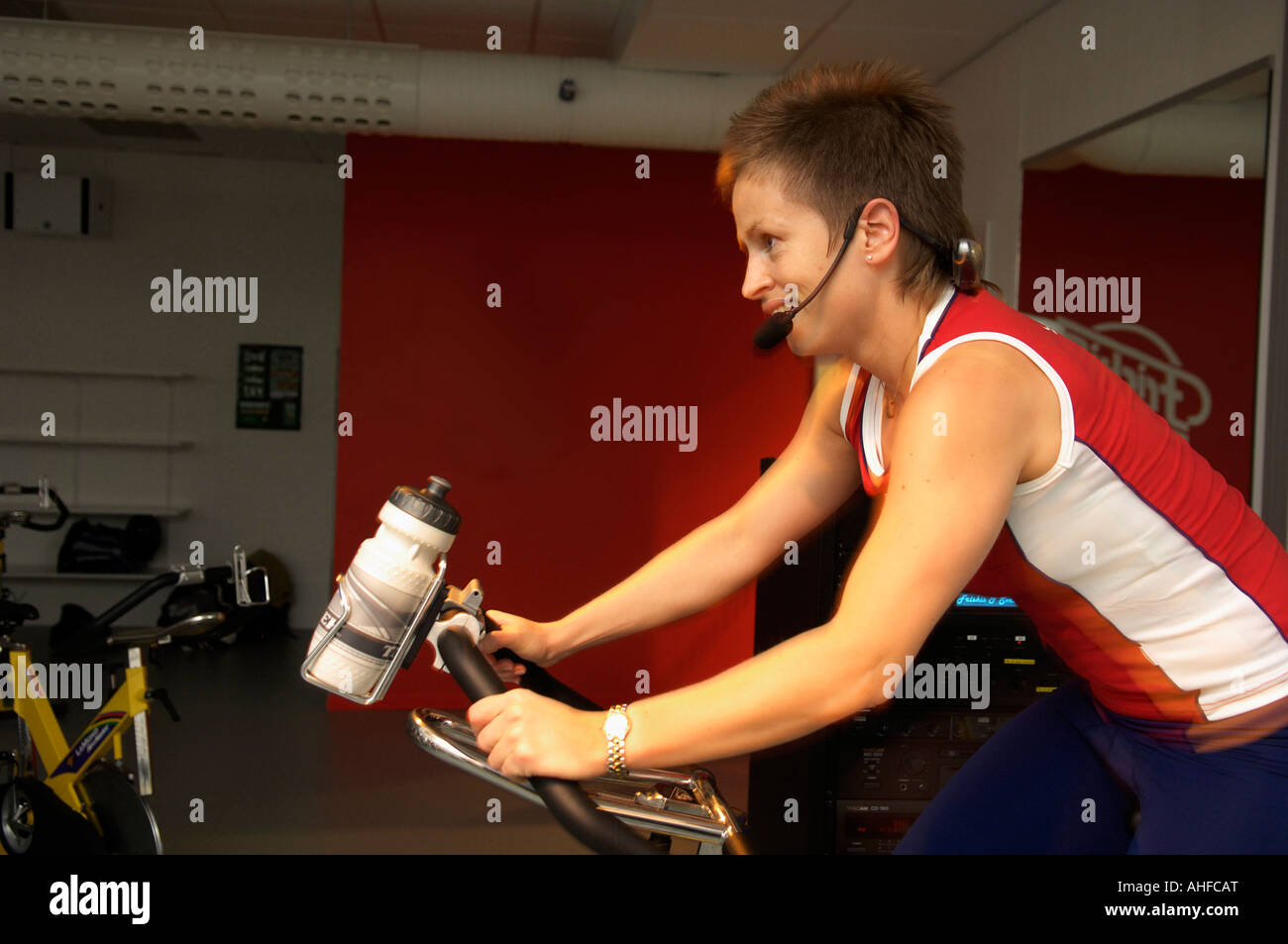 Female coach leading a group cycling spinning class in a gym Stock ...