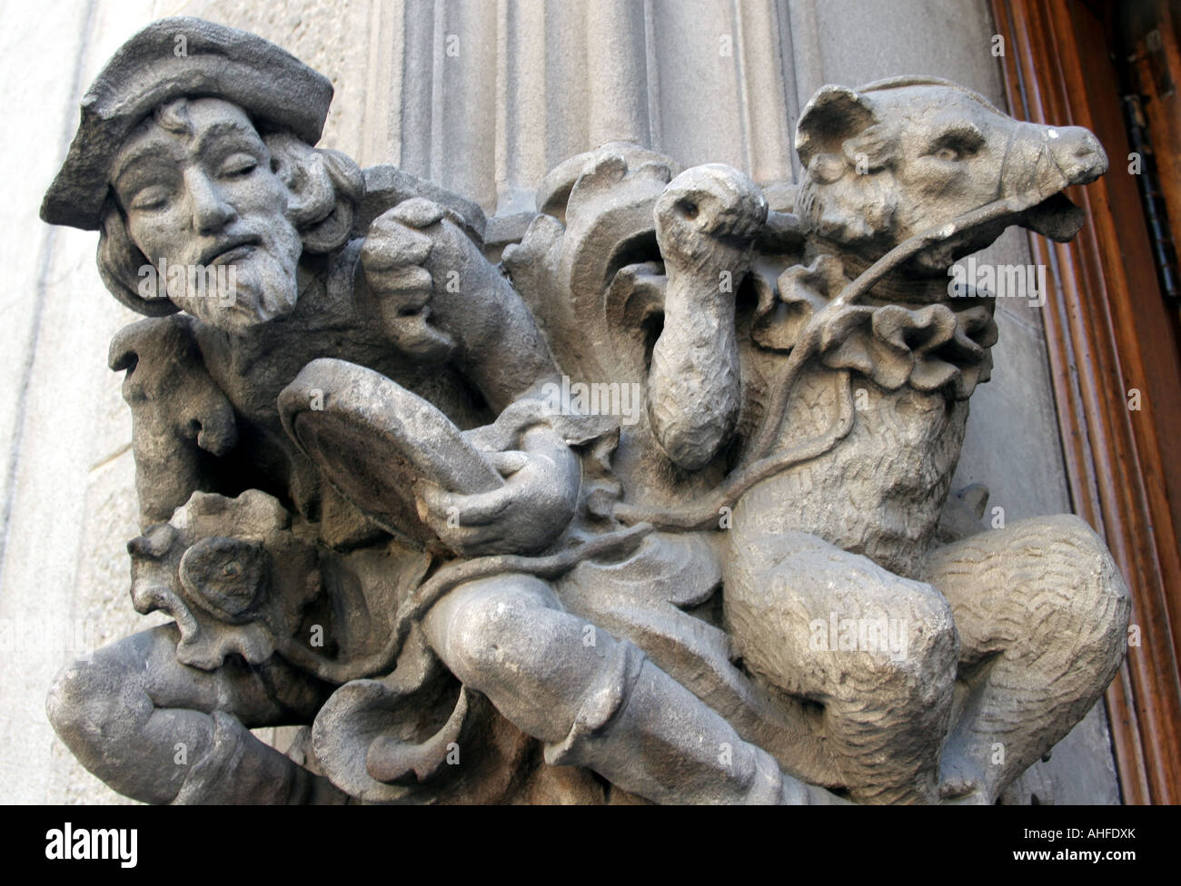 Gargoul of a man & a chained bear on a historical building in Barcelona ...