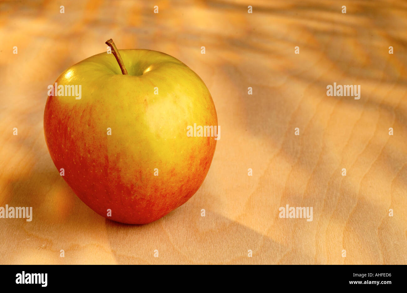 Horizontal color image of an apple sitting on a wood countertop Stock ...