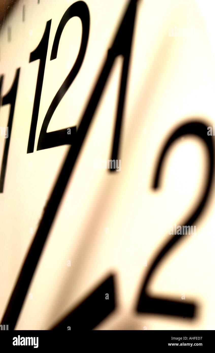 Vertical color image of a wall clock with black hands on a white wall ...