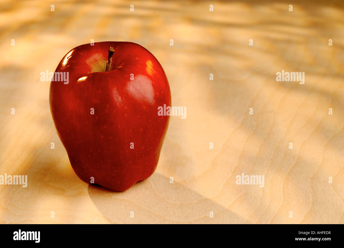 Horizontal color image of an apple sitting on a wood countertop Stock ...