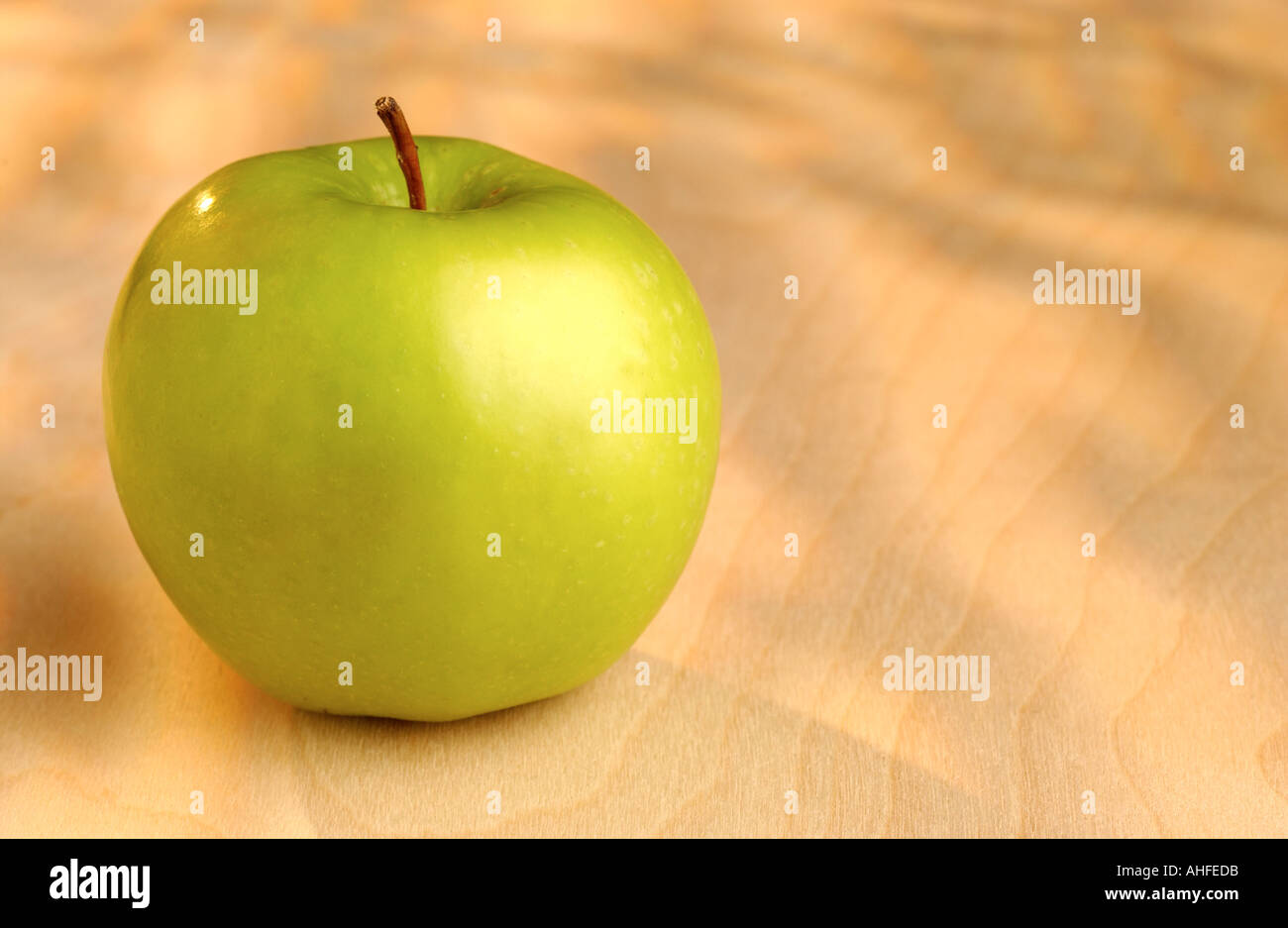 Horizontal color image of an apple sitting on a wood countertop Stock ...