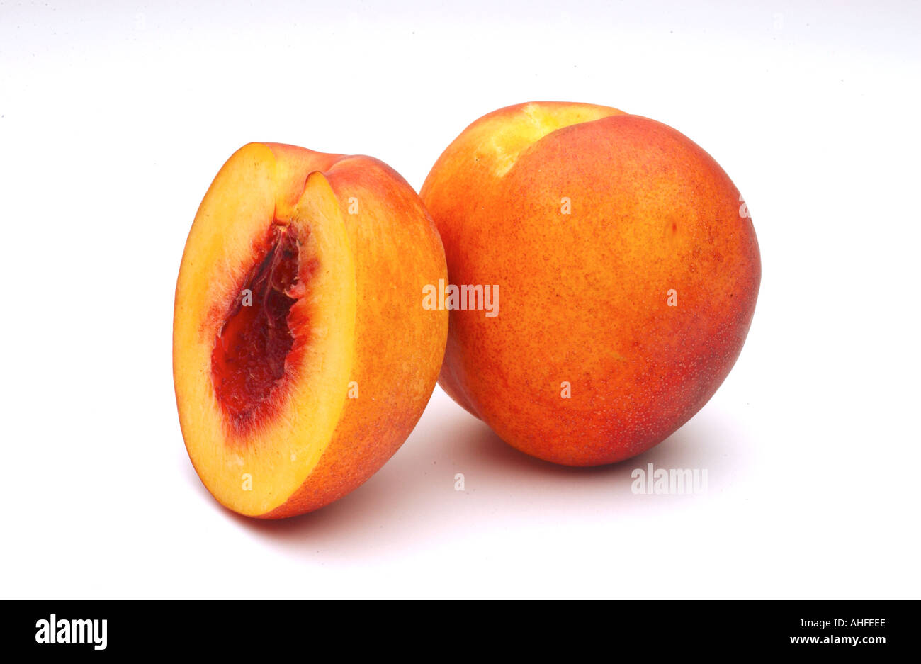 Horizontal color image of a nectarine cut in half showing the seed or ...
