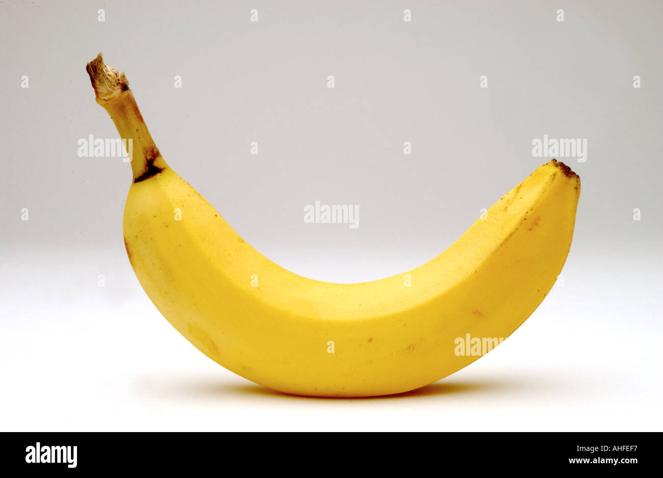Horizontal color image of a banana sitting on a whote background Stock ...
