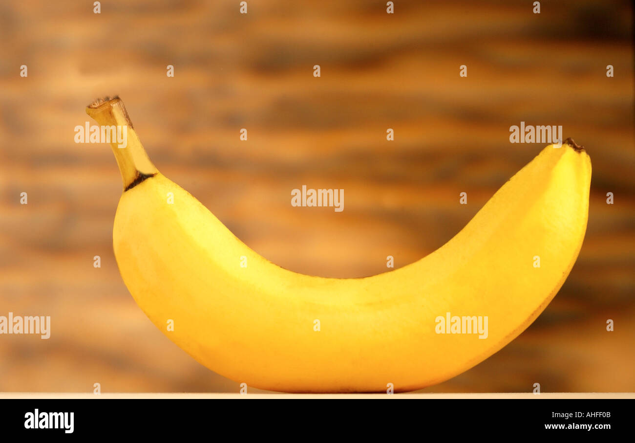 Horizontal color image of a banana sitting on a wood countertop Stock ...