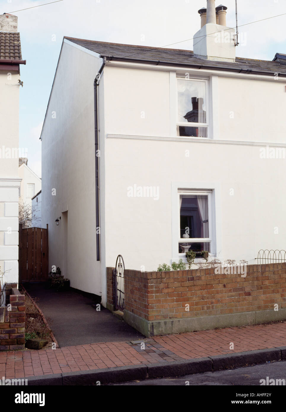 Well-painted white terraced cottage with low brick wall at the ...