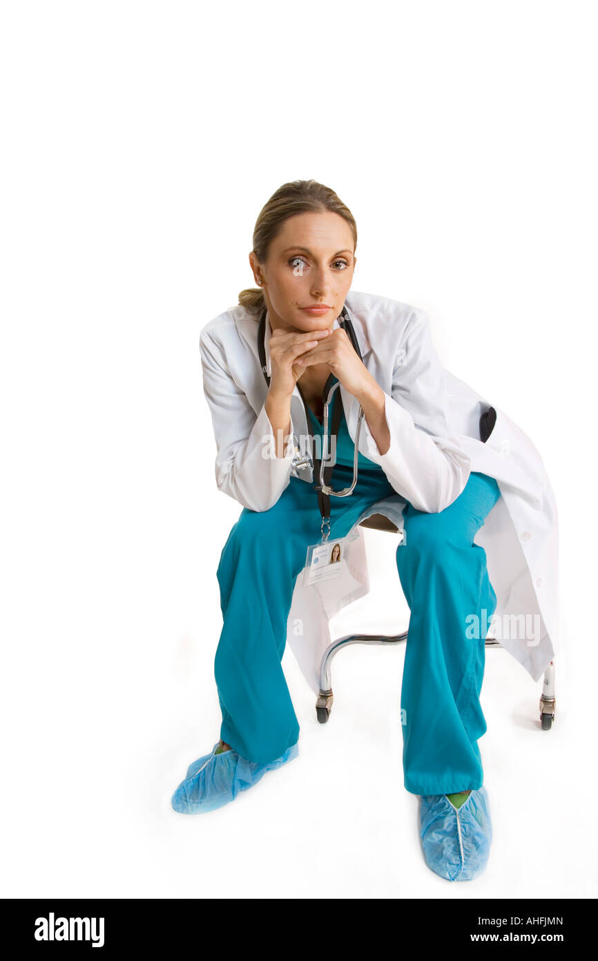 portrait of female doctor leaning on knees sitting in scrubs and lab ...