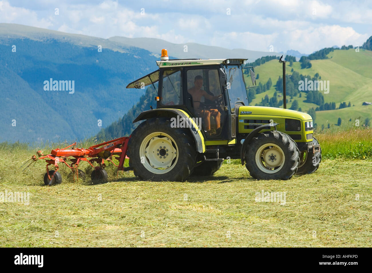 Tractor with hay machine on a mountain pasture Stock Photo - Alamy