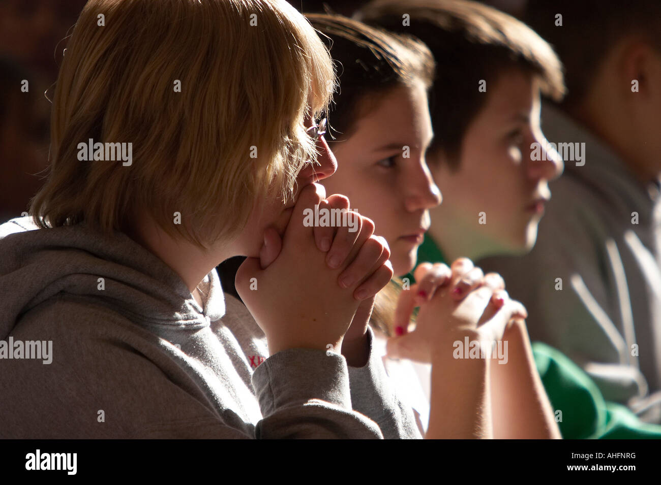 Kneeling Catholic school children praying during Mass Stock Photo - Alamy