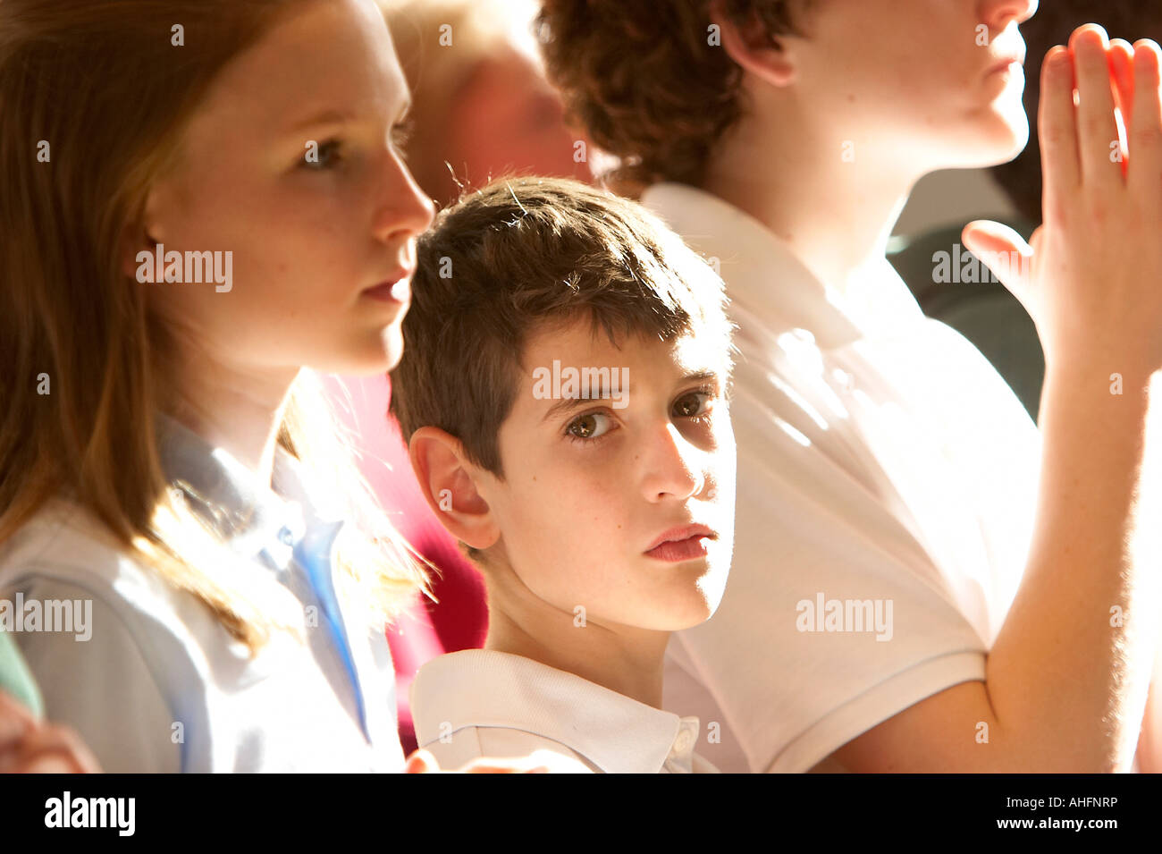 Kneeling Catholic school children praying during Mass Stock Photo - Alamy