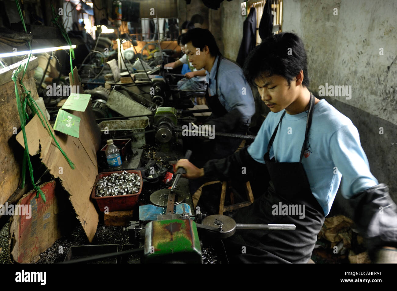 Chinese workers produce metal components in a private metal work ...