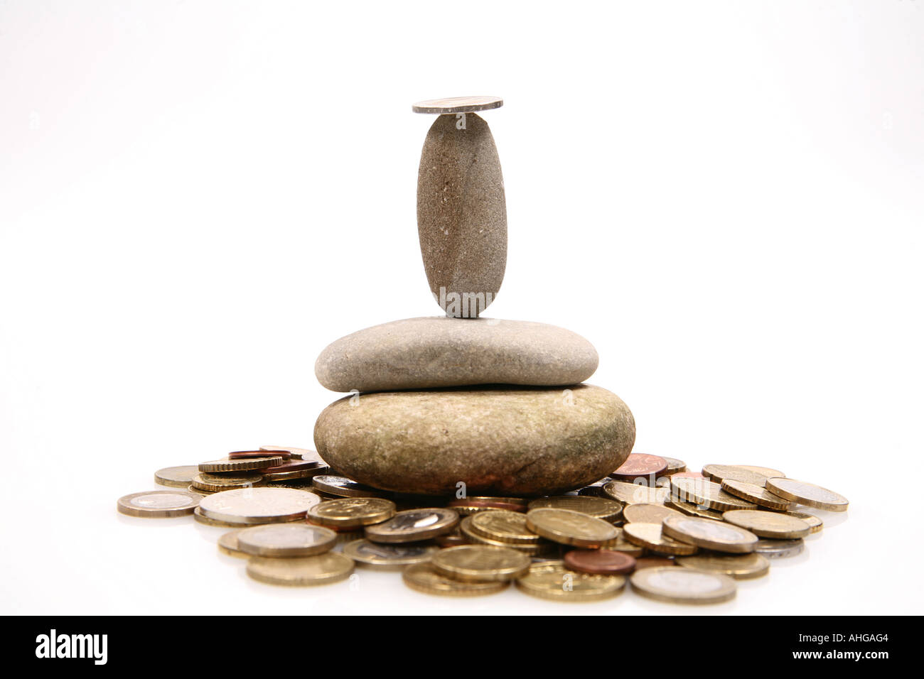 Coins and Pepples on white background as a symbol for financial balance ...