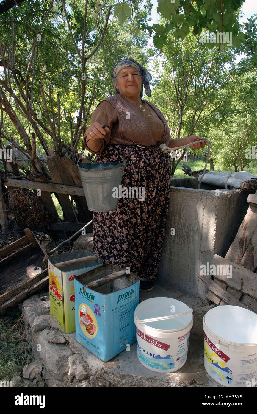 Woman getting water well bucket hi-res stock photography and images - Alamy