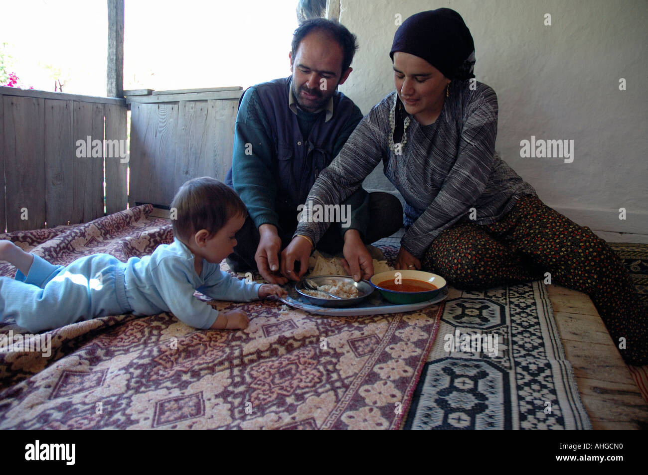 Family eating a mid day meal in their home in the village of Bezirgan ...