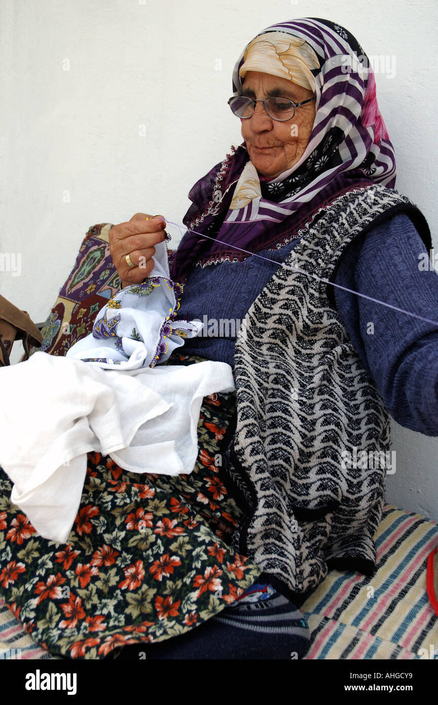 Turkish woman sitting on her porch sewing and embroidering in village ...