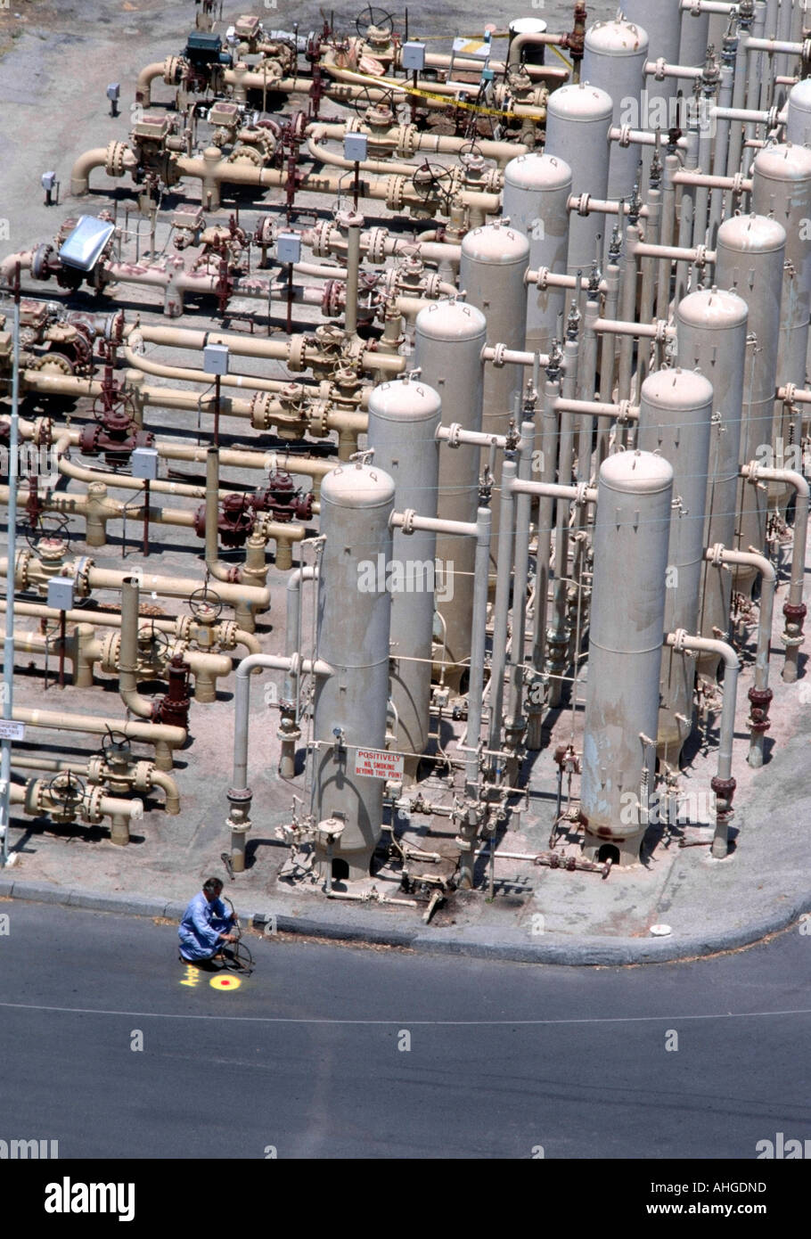 A workman at a gas plant with pipelines in background Stock Photo - Alamy