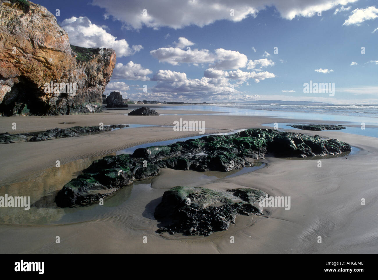 Low tide brings puddles of sea water into shore and around rock ...