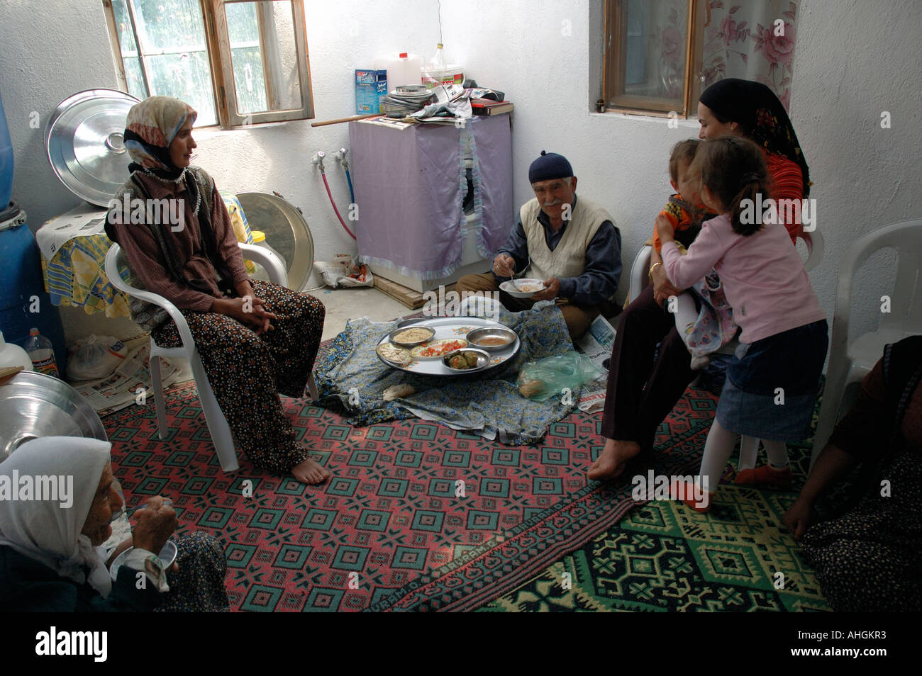 Extended Turkish family having midday meal in their home in small rural ...