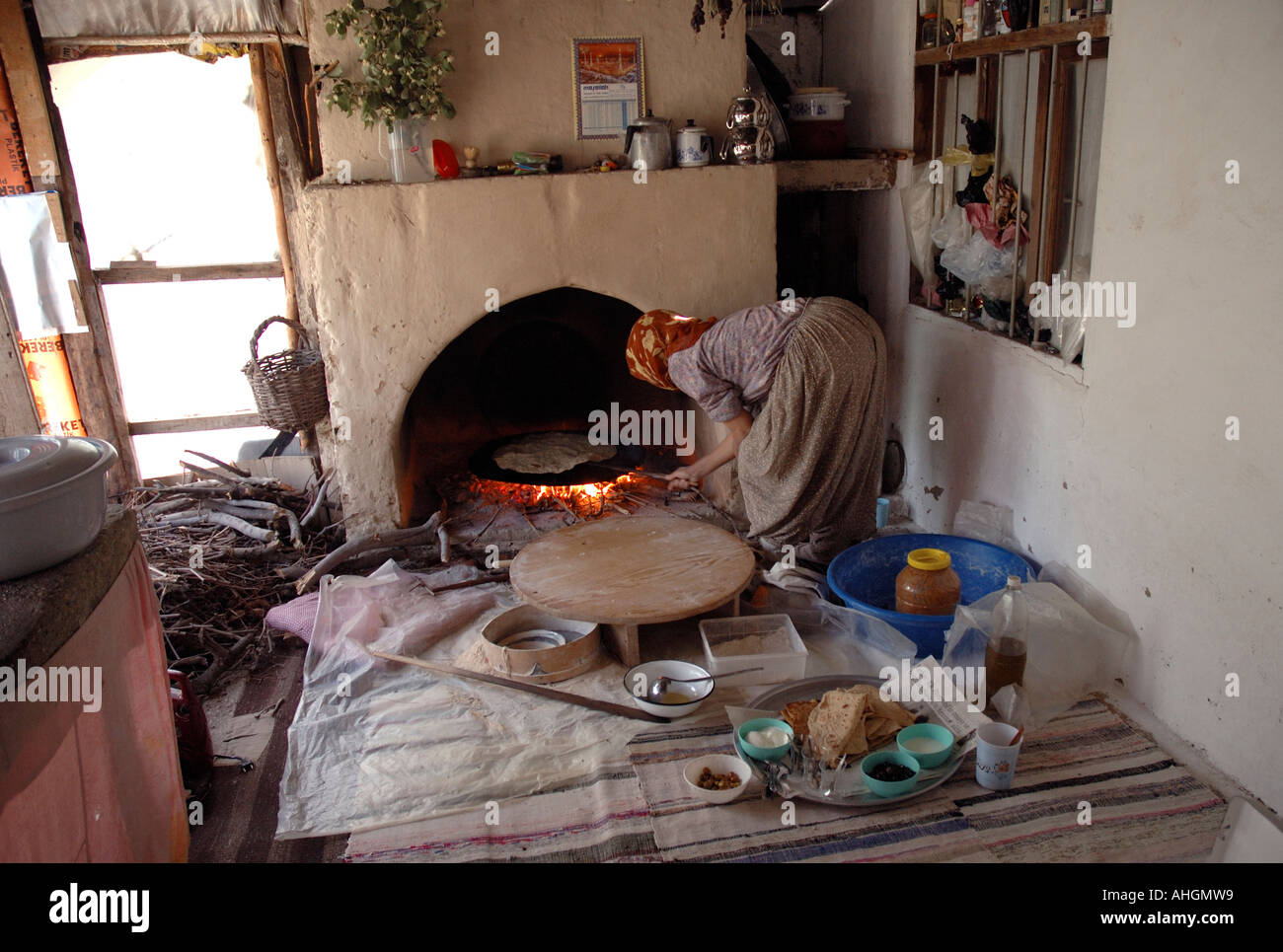 Turkish woman making flat bread in fireplace in home near village of ...
